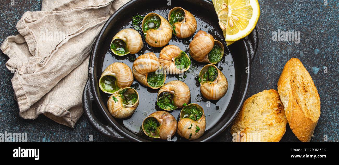Escargots de Bourgogne Snails with Garlic Butter and Parsley in black ...