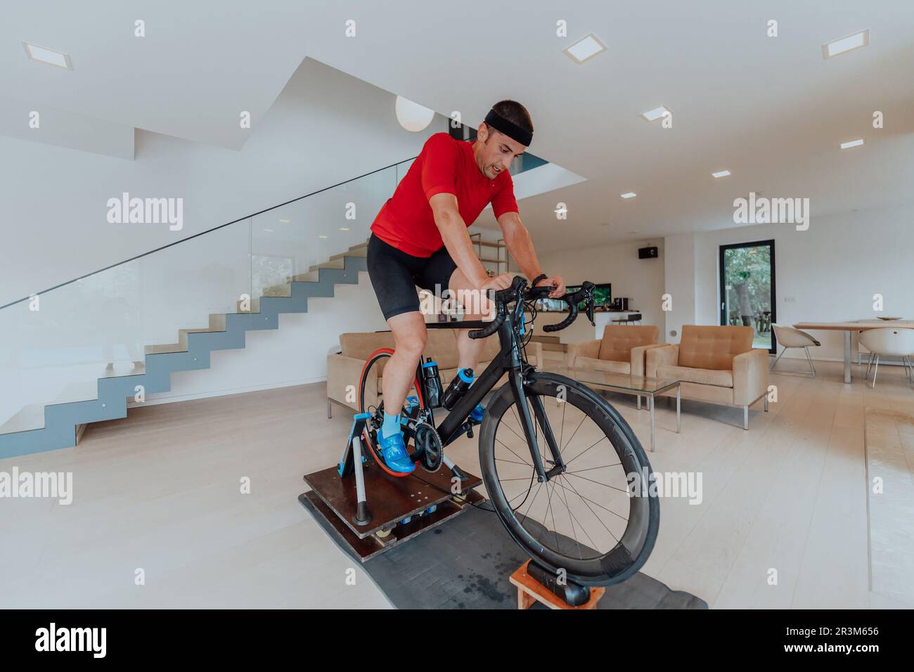 A man riding a triathlon bike on a machine simulation in a modern ...