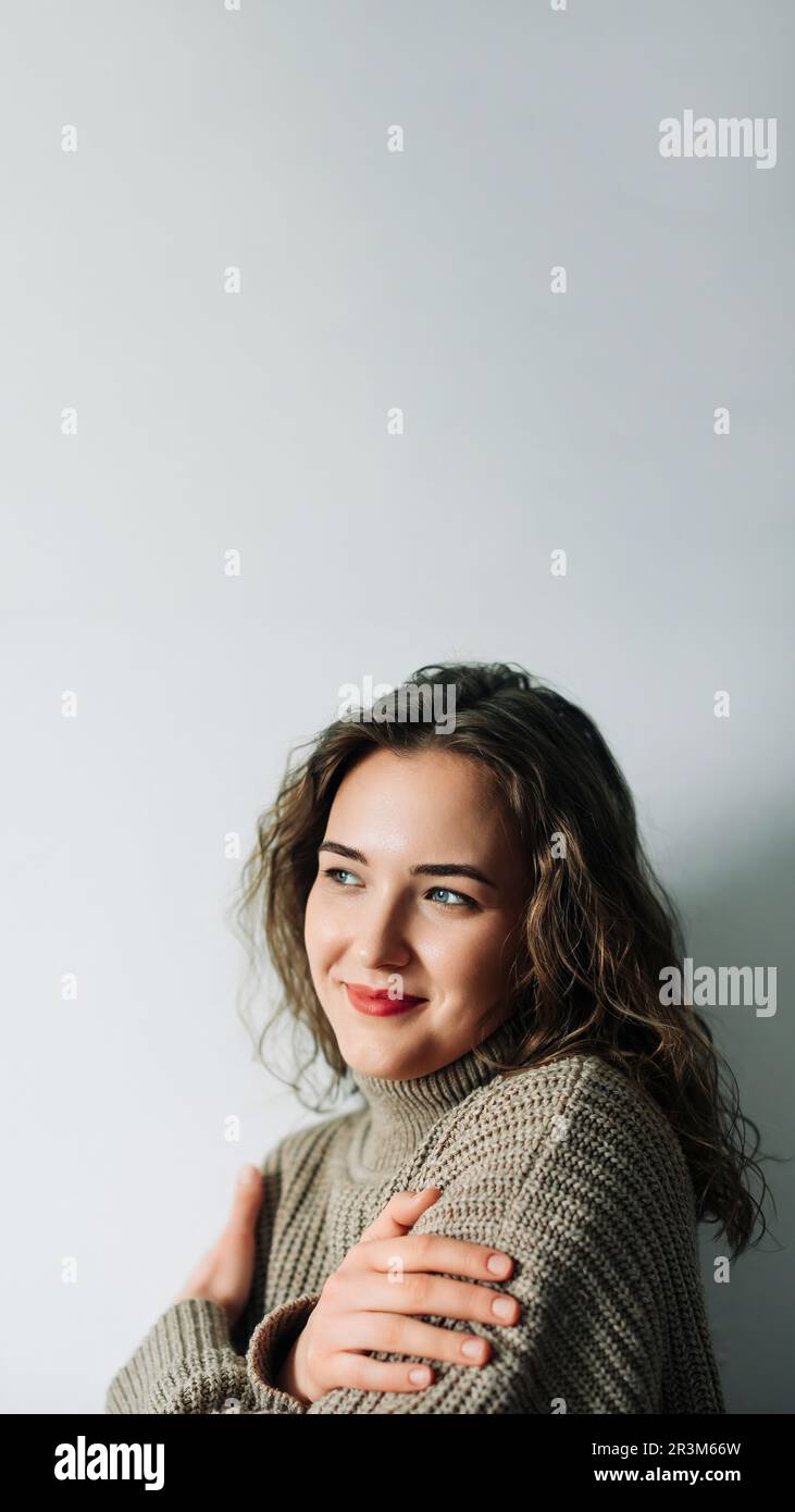 Romantic wife eagerly anticipating husband's return, standing by window ...