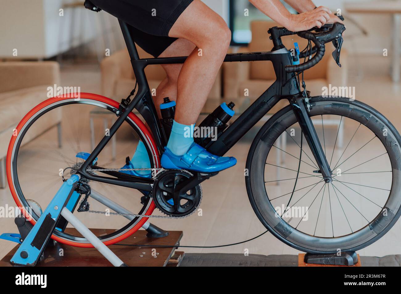 A man riding a triathlon bike on a machine simulation in a modern ...