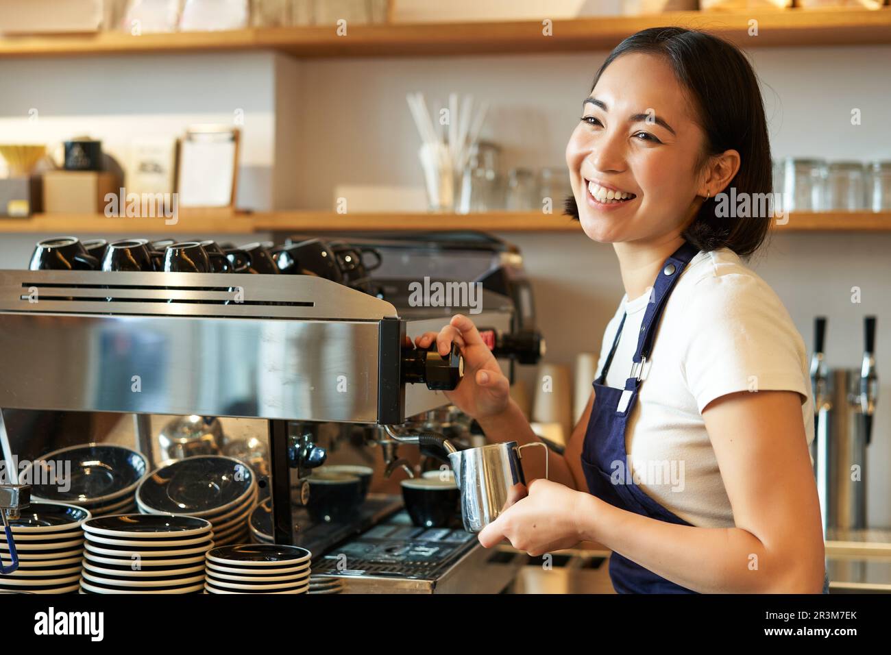 Happy asian girl barista, working in cafe, brewing coffee, prepare ...