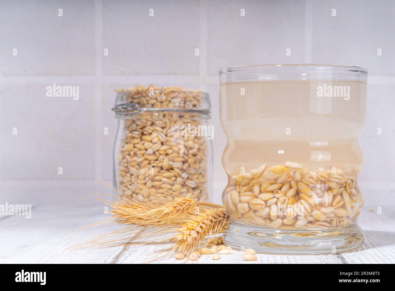 Simple barley orzo infused water drink in glass, with raw and cooked ...