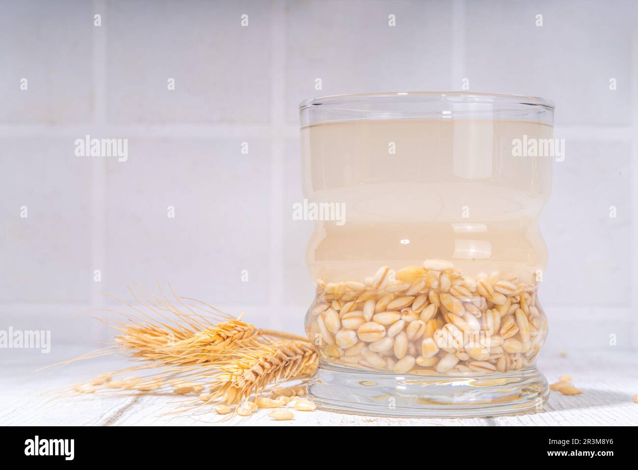 Simple barley orzo infused water drink in glass, with raw and cooked ...