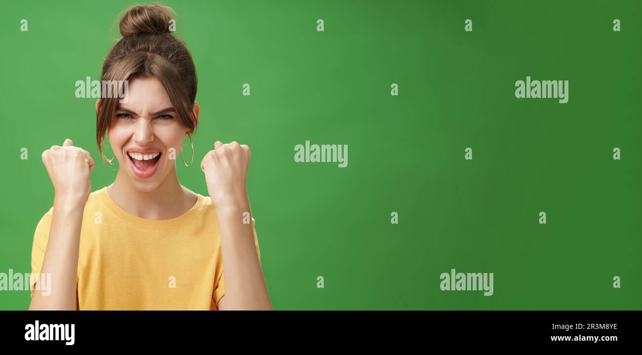 Woman with spirit of winner raising clenched fists smiling excited and ...