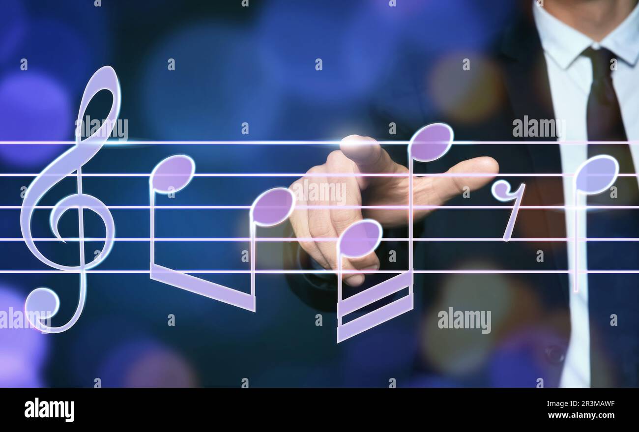 Musician pointing at staff with music notes and symbols on color ...