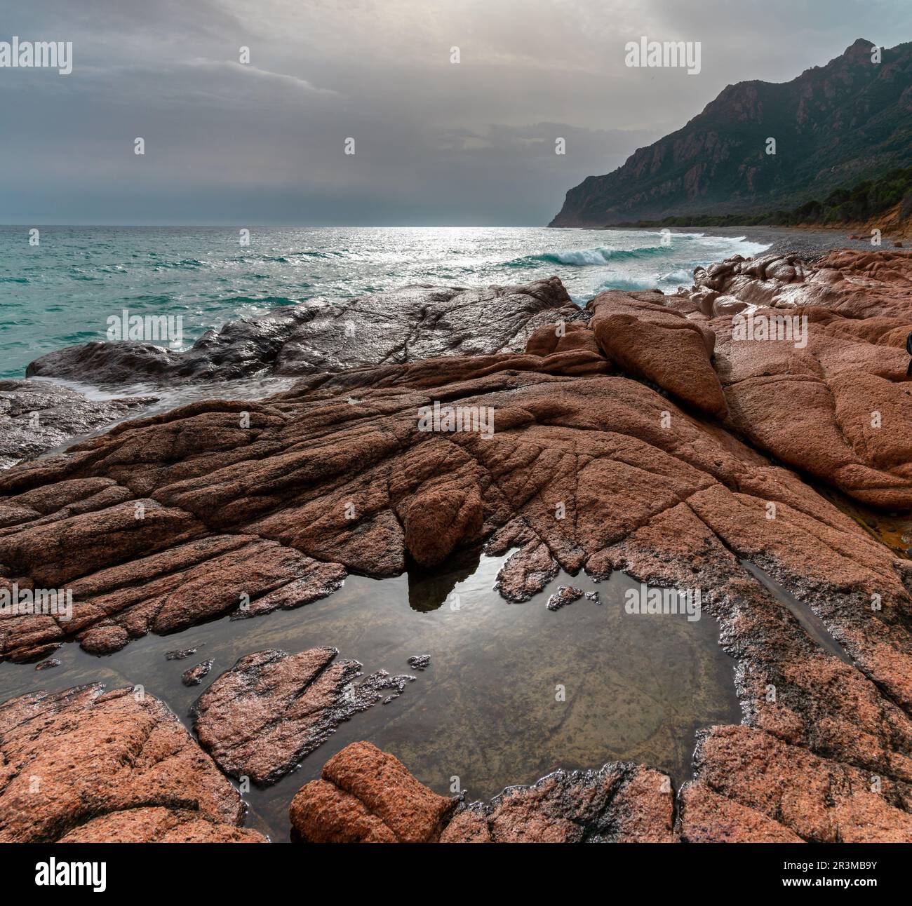View of Coccorocci Beach with tidal pools in the red stone and a view ...