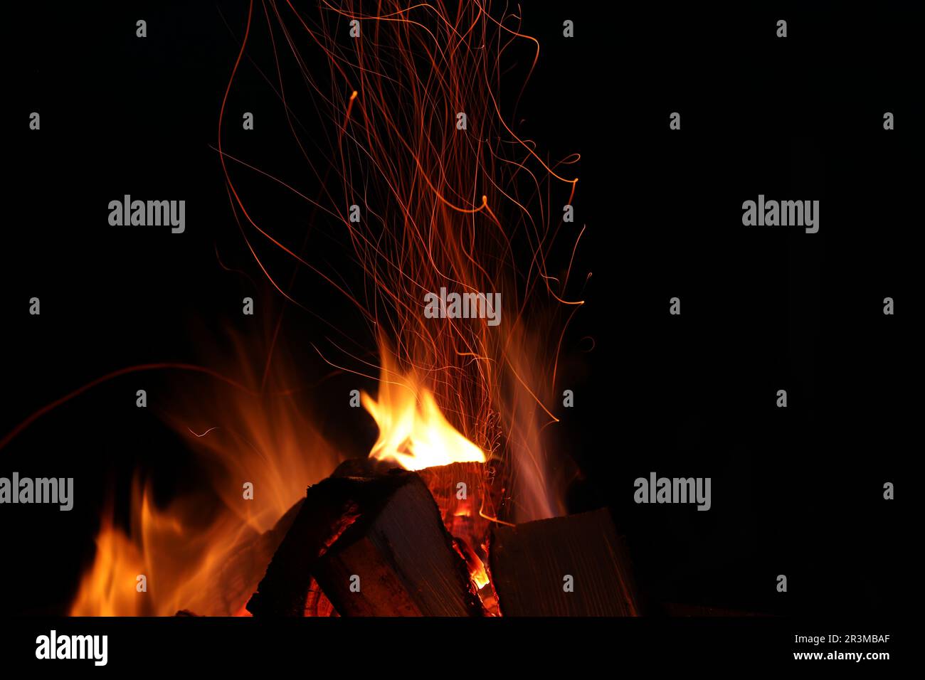 Beautiful bright bonfire with burning wood outdoors at night, space for ...