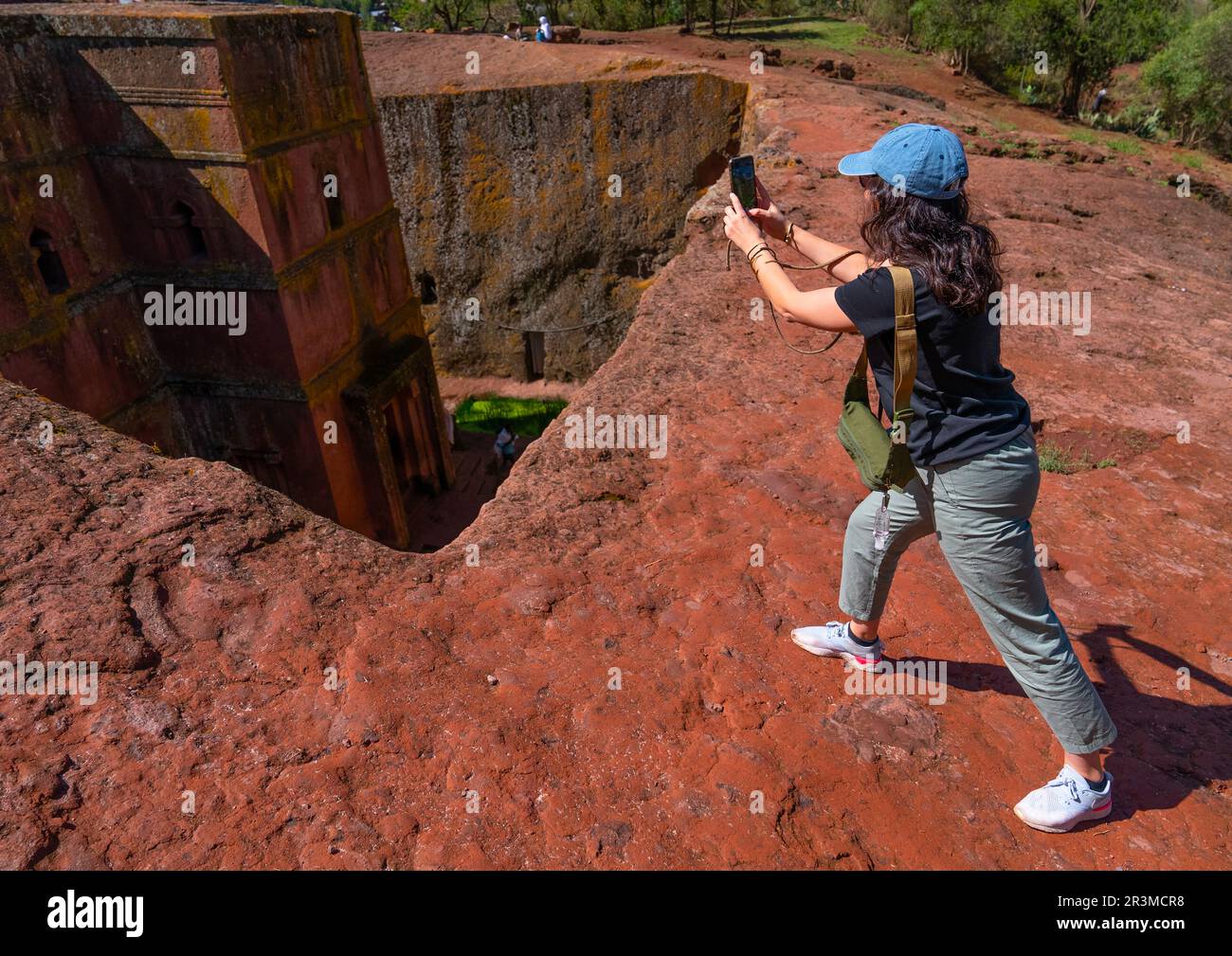 European tourist taking picture of St Georges rock-hewn church from the ...