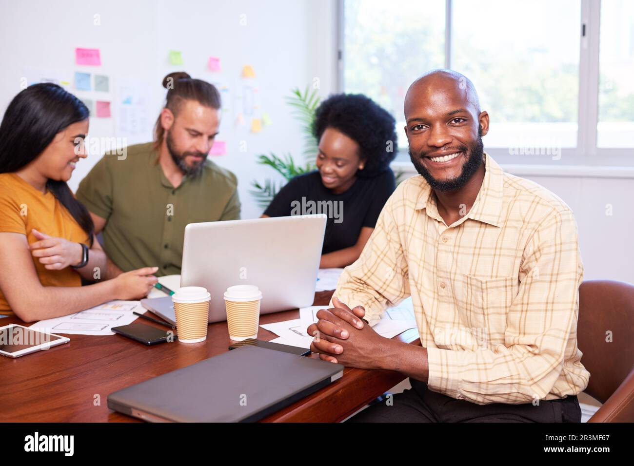 Portrait of smiling Black man, development team, mobile app coding ...
