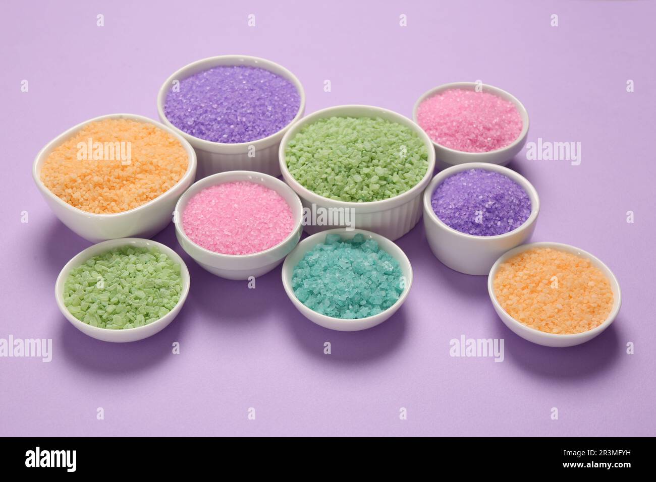 Different types of aromatic sea salt on purple background Stock Photo ...