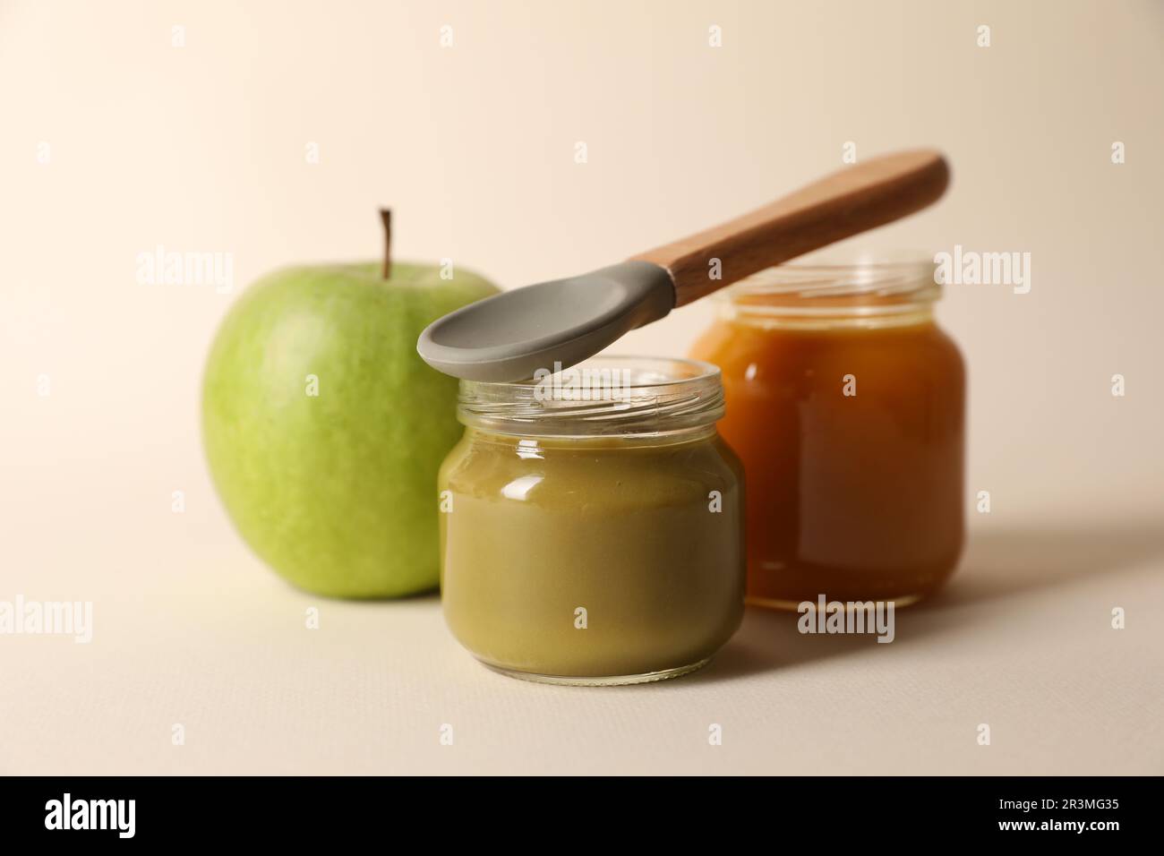 Healthy baby food, apple and spoon on beige background Stock Photo - Alamy