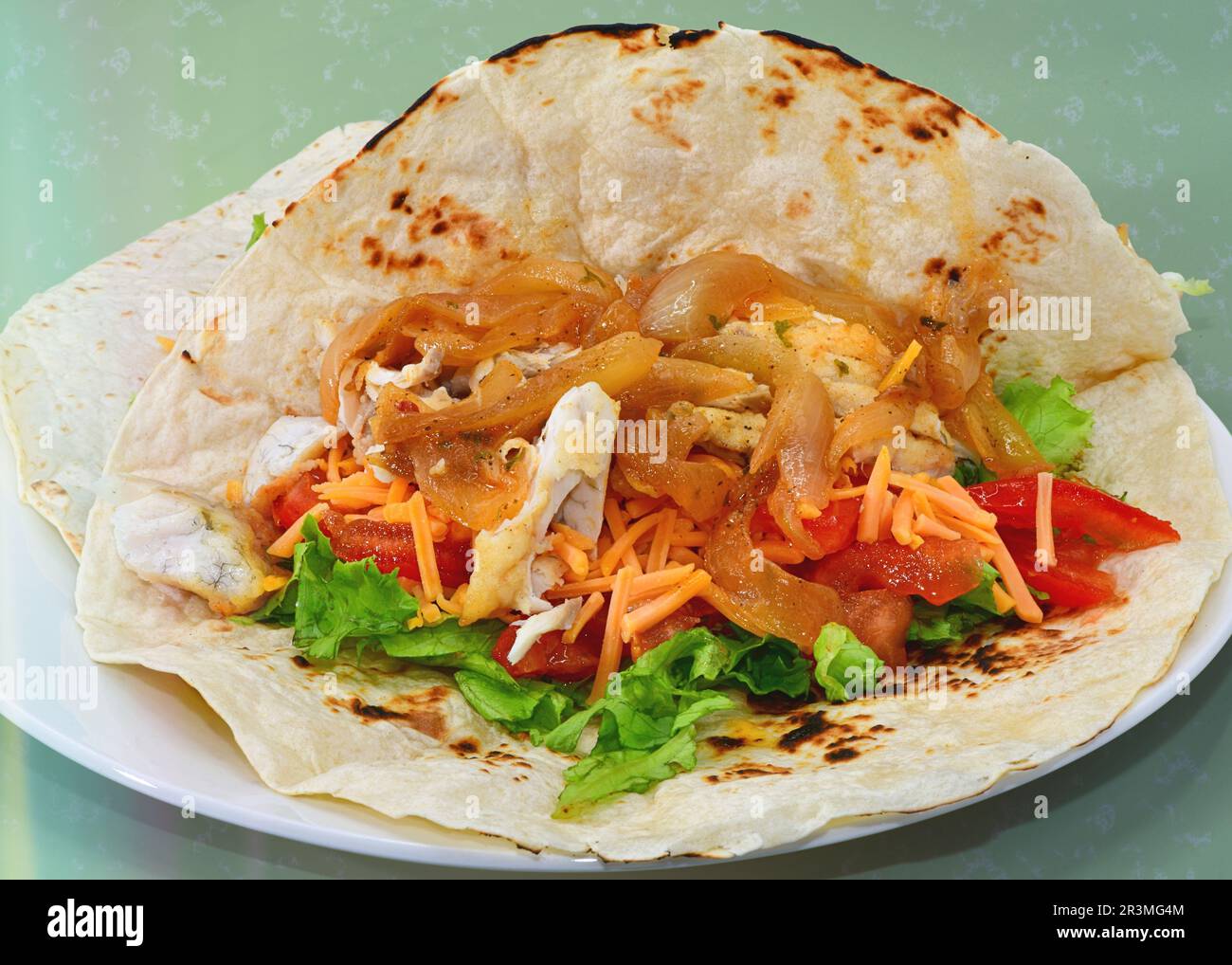 Fish with onions and salad in a tortilla Stock Photo - Alamy