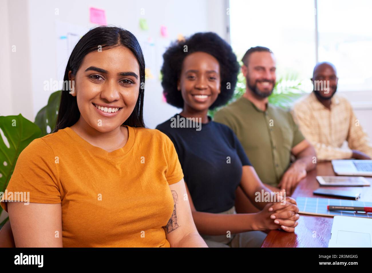 Portrait of beautiful Indian woman, diverse colleagues boardroom table ...