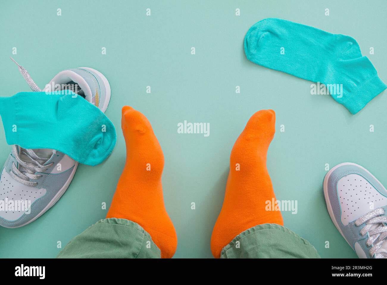 The feet of a man in orange socks with his sneakers take off. Mint ...