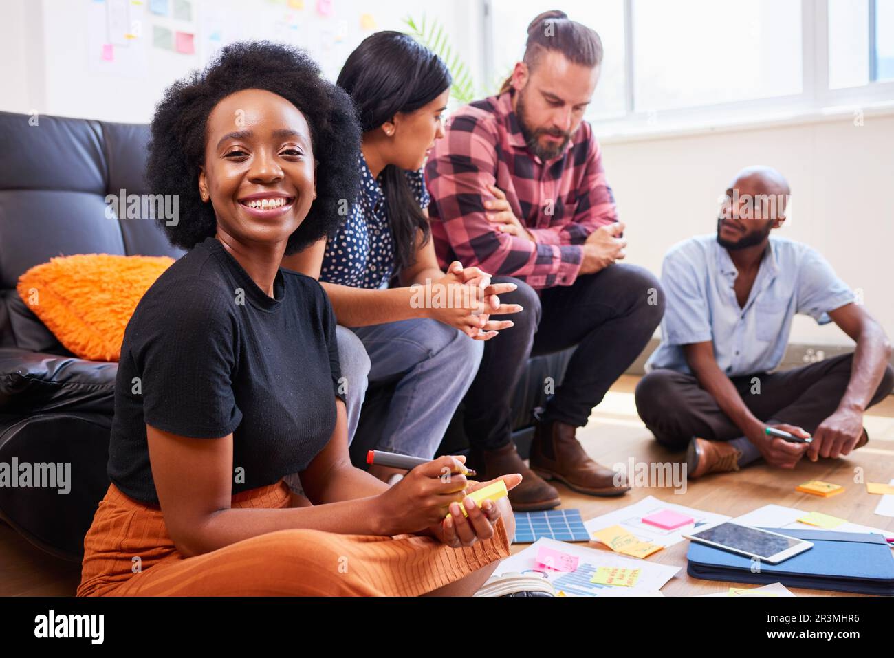 Portrait of female UX designer sitting on floor, creative brainstorm ...