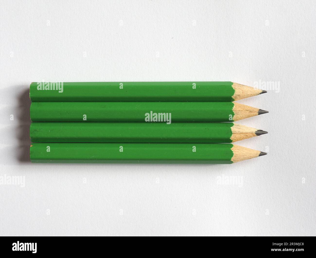 Four green pencils on paper sheet Stock Photo - Alamy