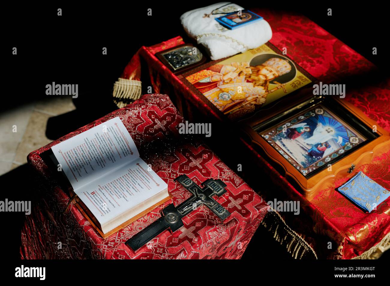 Opened Holy Bible is on the lectern near cross are against background ...