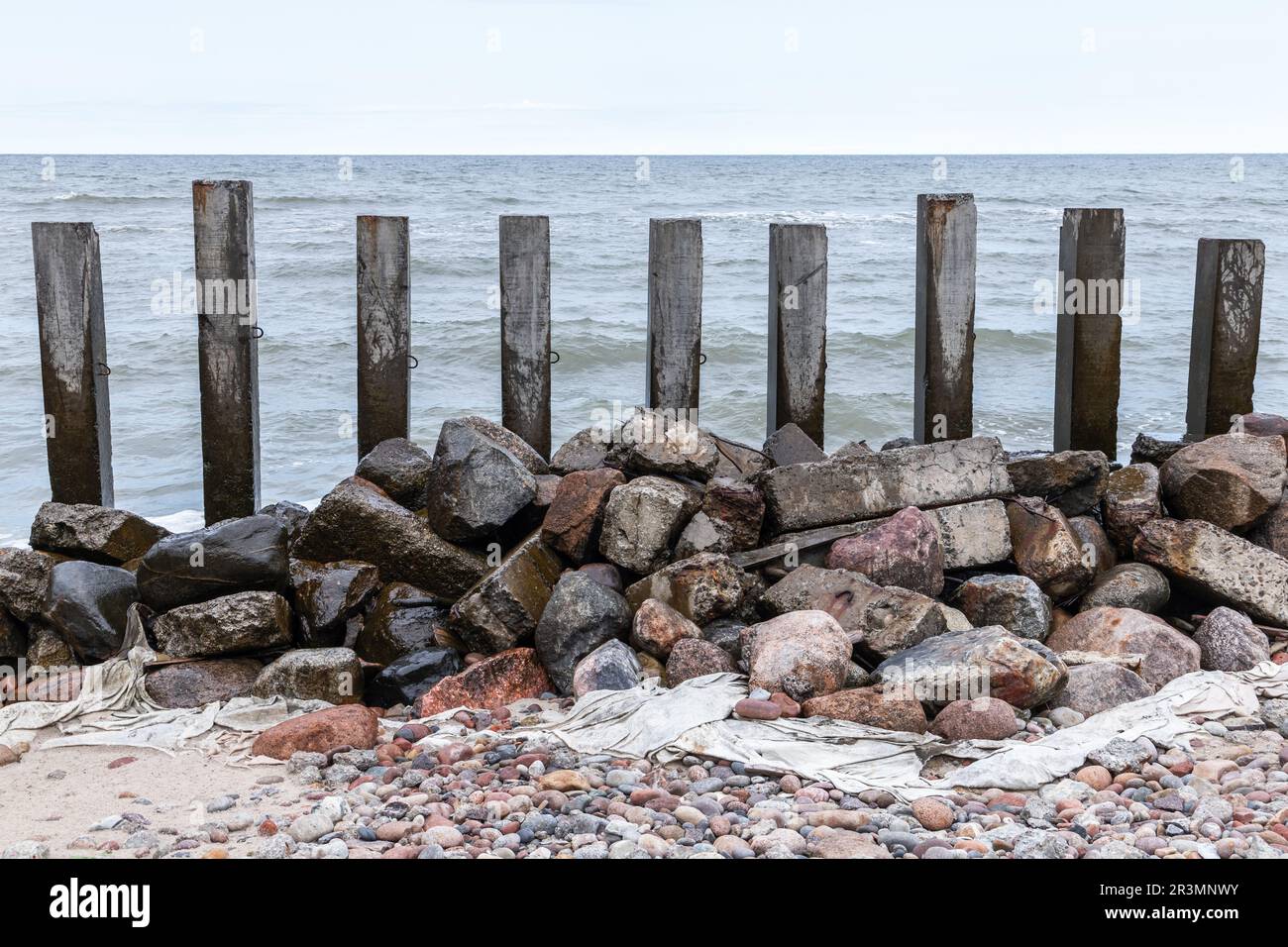 Concrete pillars and stones as a parts of a broken breakwater, Baltic ...