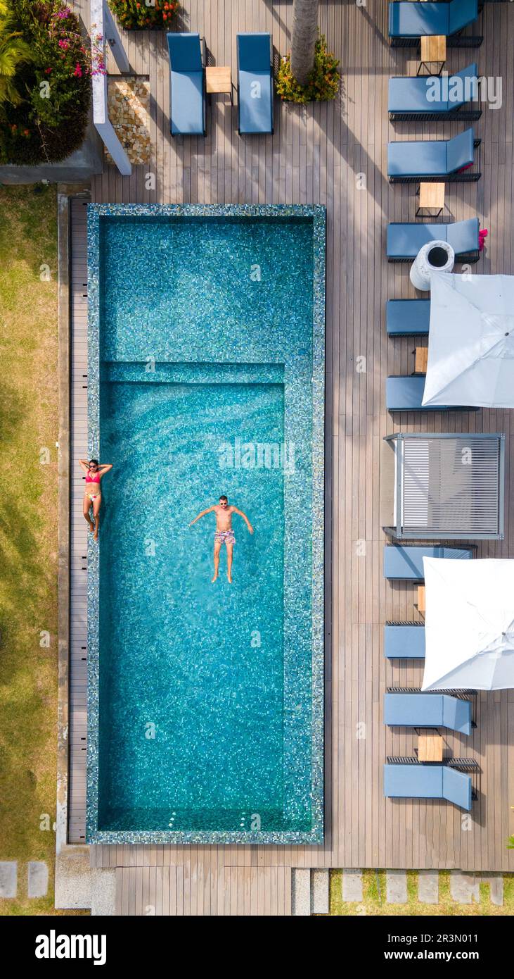 Drone aerial view from above at pool,couple men and women in pool ...