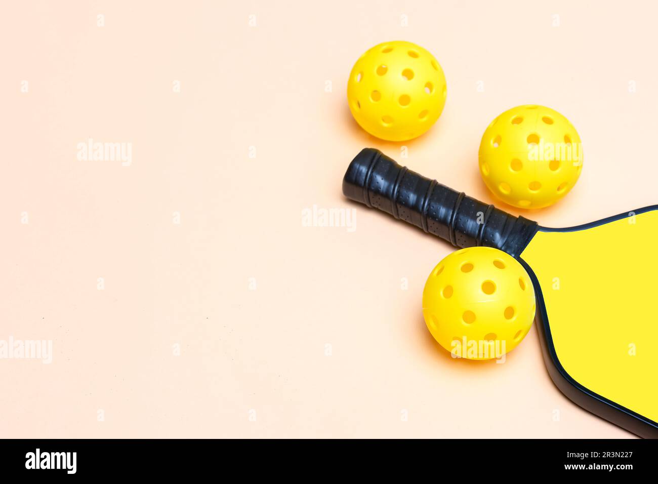 Yellow pickleball racket and ball on beige background. Horizontal ...