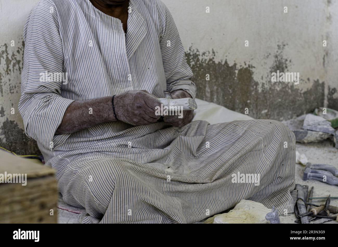 Hands of a male Egyptian sculptor while working with a stone alabaster ...