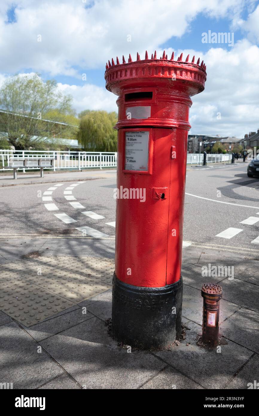 Strange pointed top on red letter post box with a miniature version ...