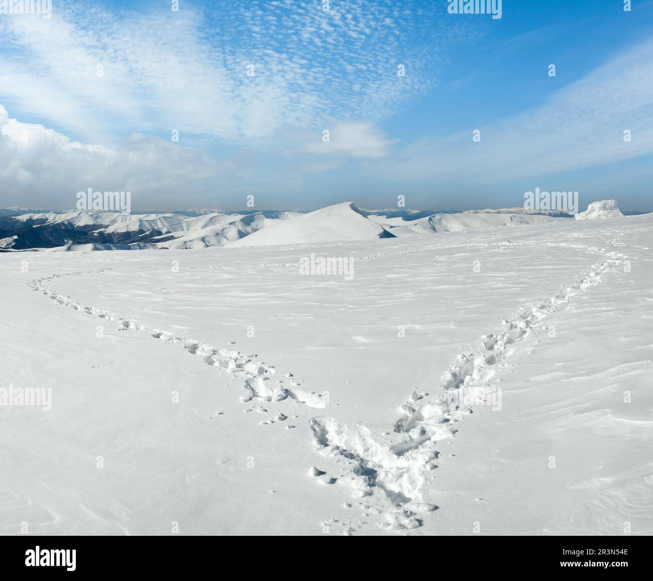 Human footprint form the heart shape on snow-covered mountainside ...