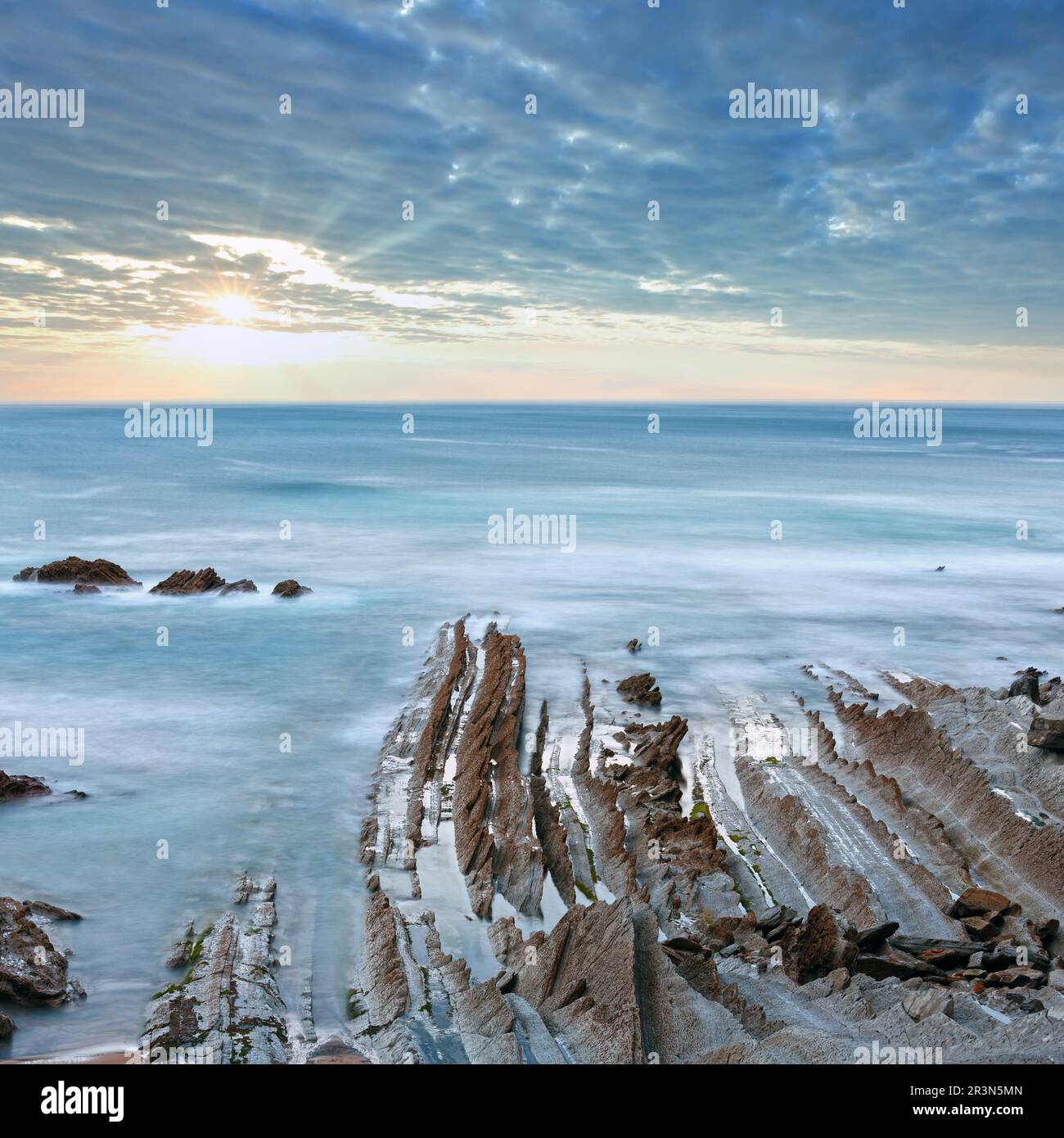 Twilight ocean coast with ribbed stratiform rock formations. (Atlantic ...