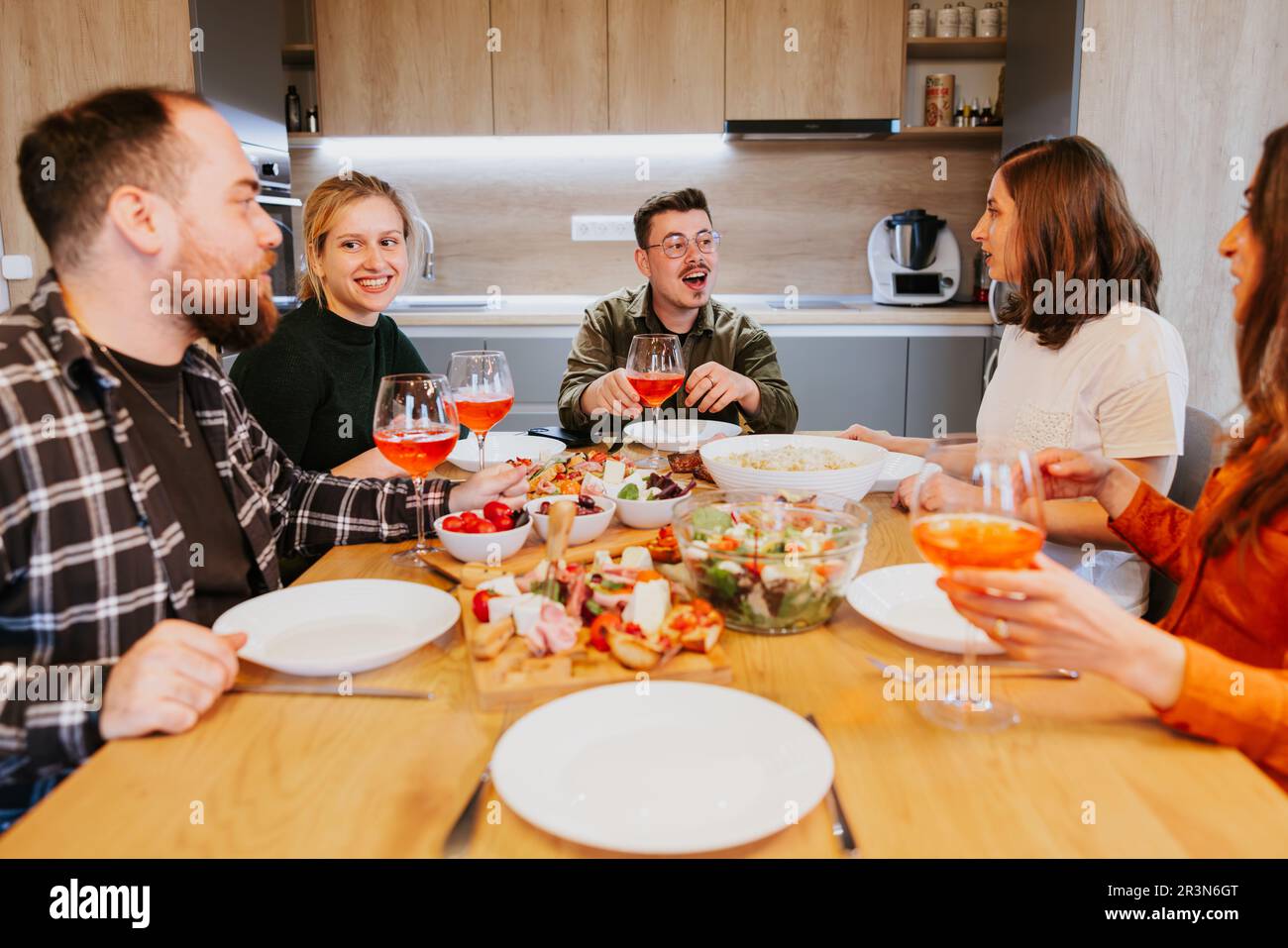Friends enjoying eating together and laughing Stock Photo - Alamy
