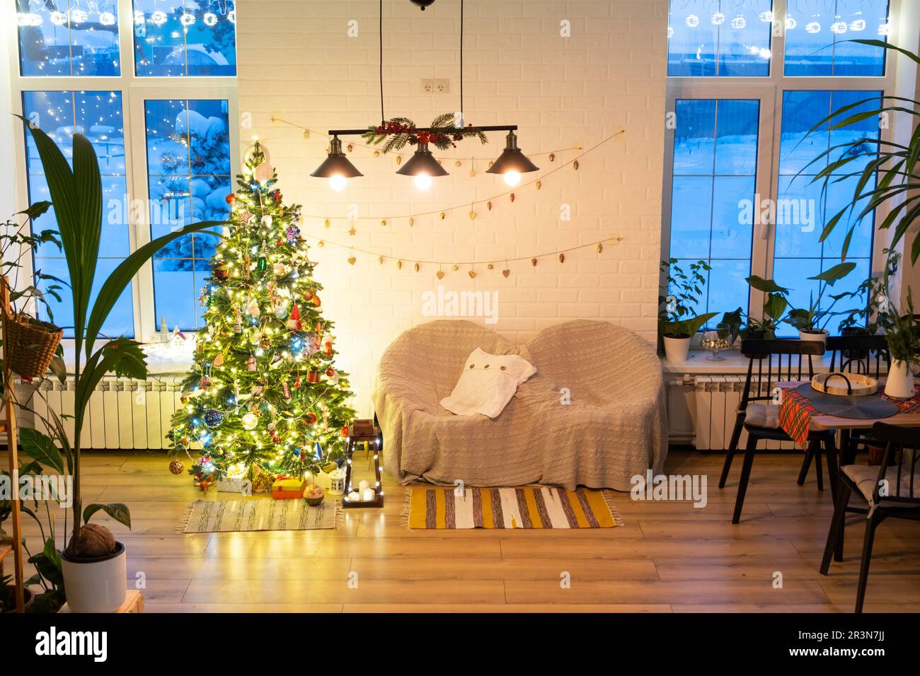 Christmas tree in white interior of a house with loft-style brick walls ...