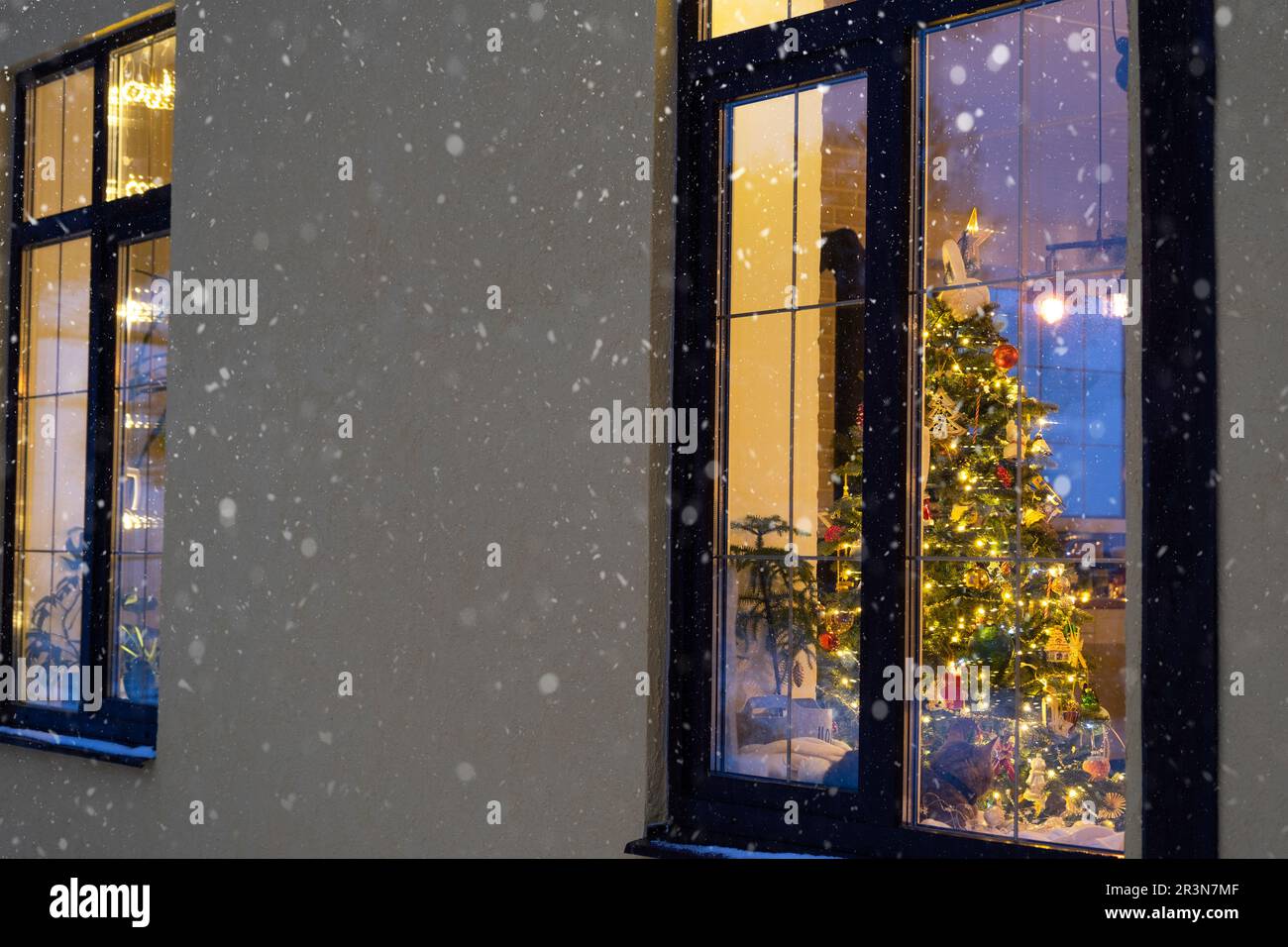 Cozy festive window of the house outside with the warm light of fairy ...