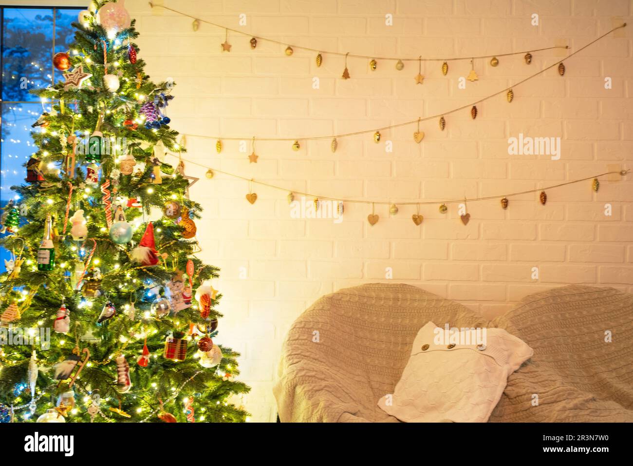 Christmas tree in white interior of a house with loft-style brick walls ...