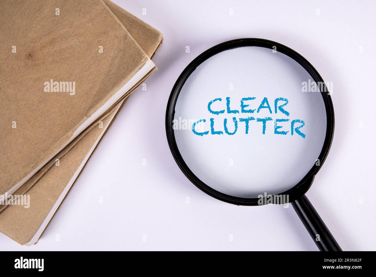 Clear Clutter. Magnifying glass and book on white background Stock Photo - Alamy
