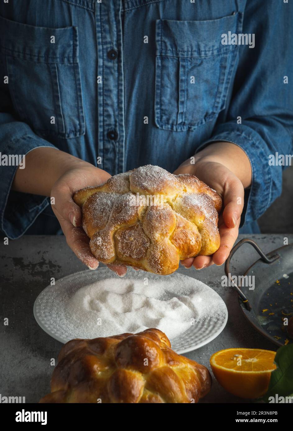 Woman preparing Pan de muertos bread of the dead for Mexican day of the ...