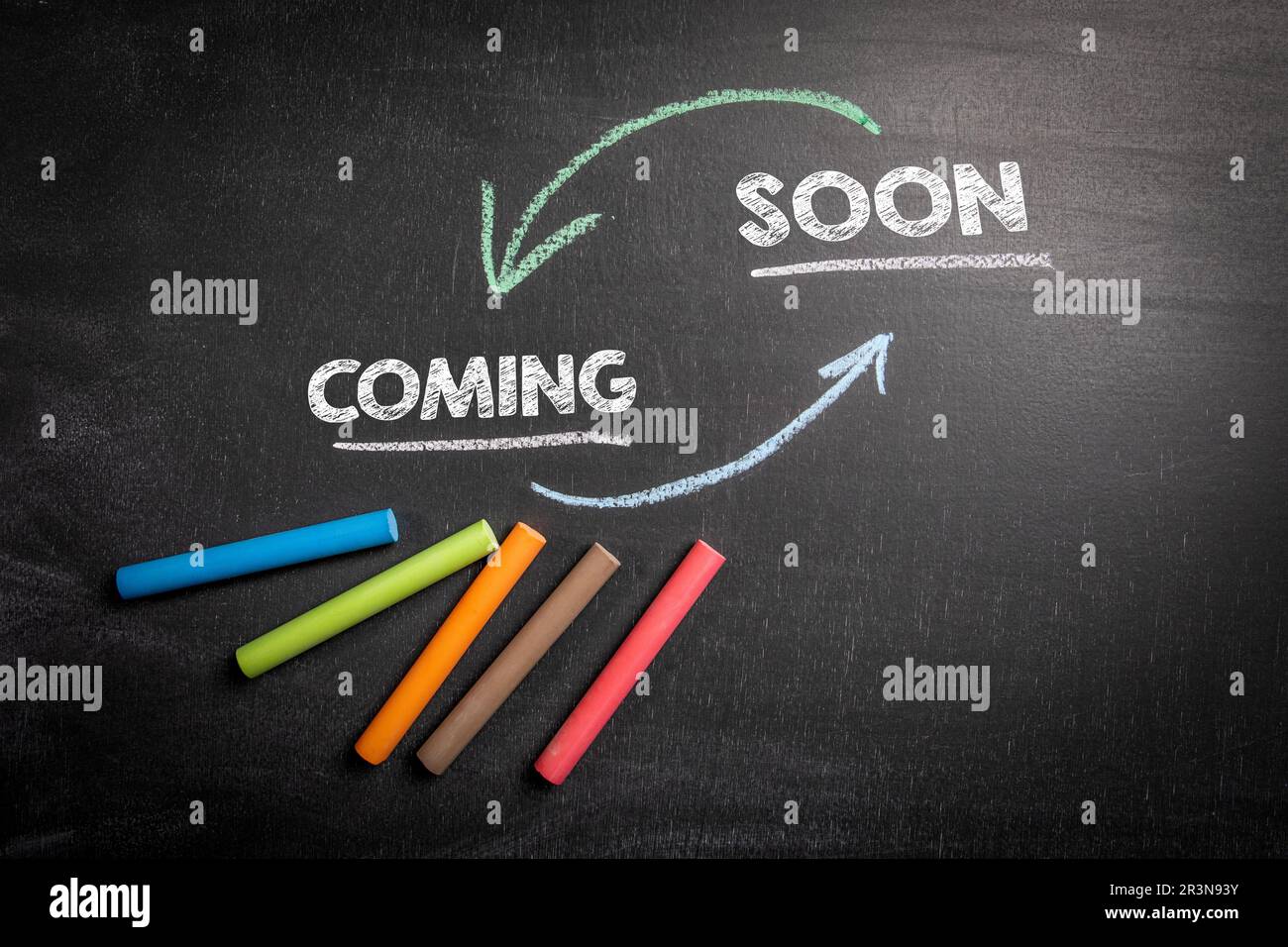 Coming Soon Concept. Text and colored pieces of chalk on a blackboard ...