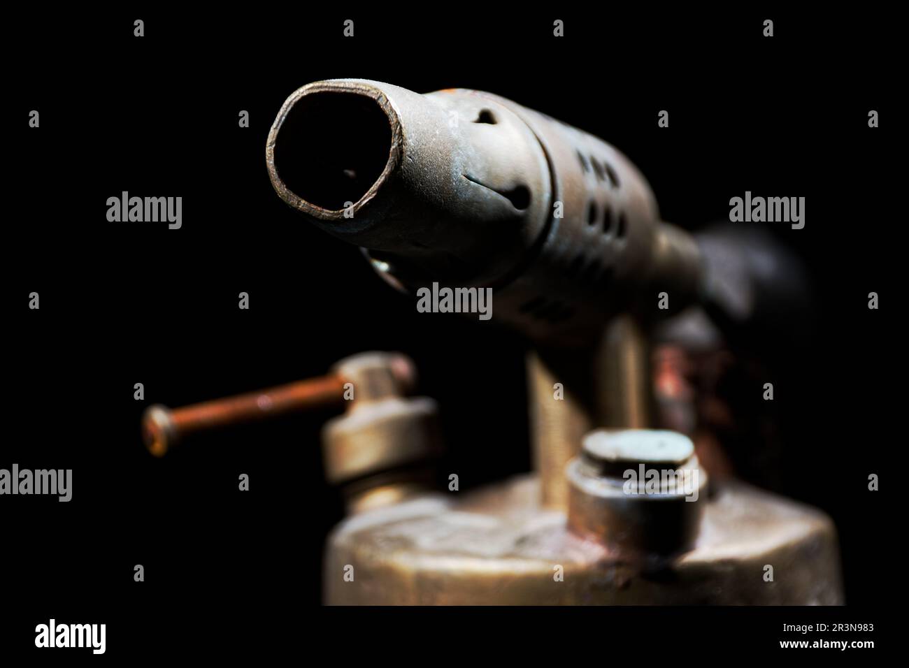 old and vintage blow torch isolated on black background with rust and ...