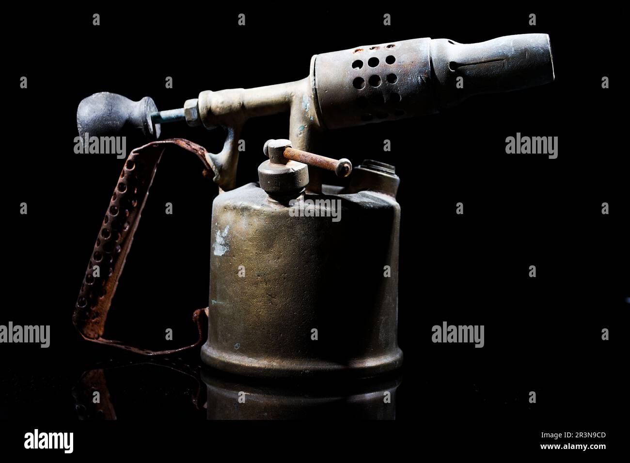 old and vintage blow torch isolated on black background with rust and ...