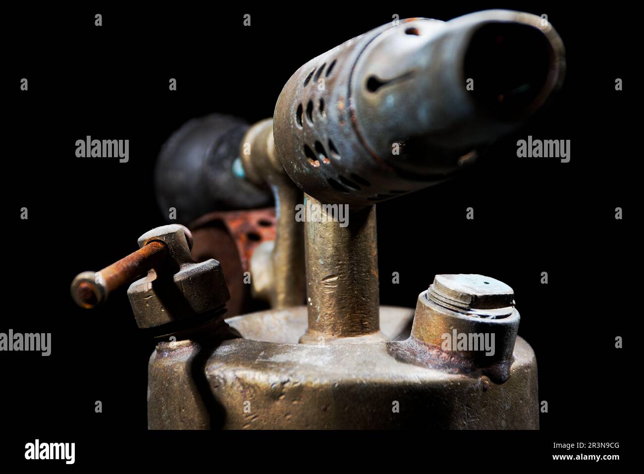 old and vintage blow torch isolated on black background with rust and ...