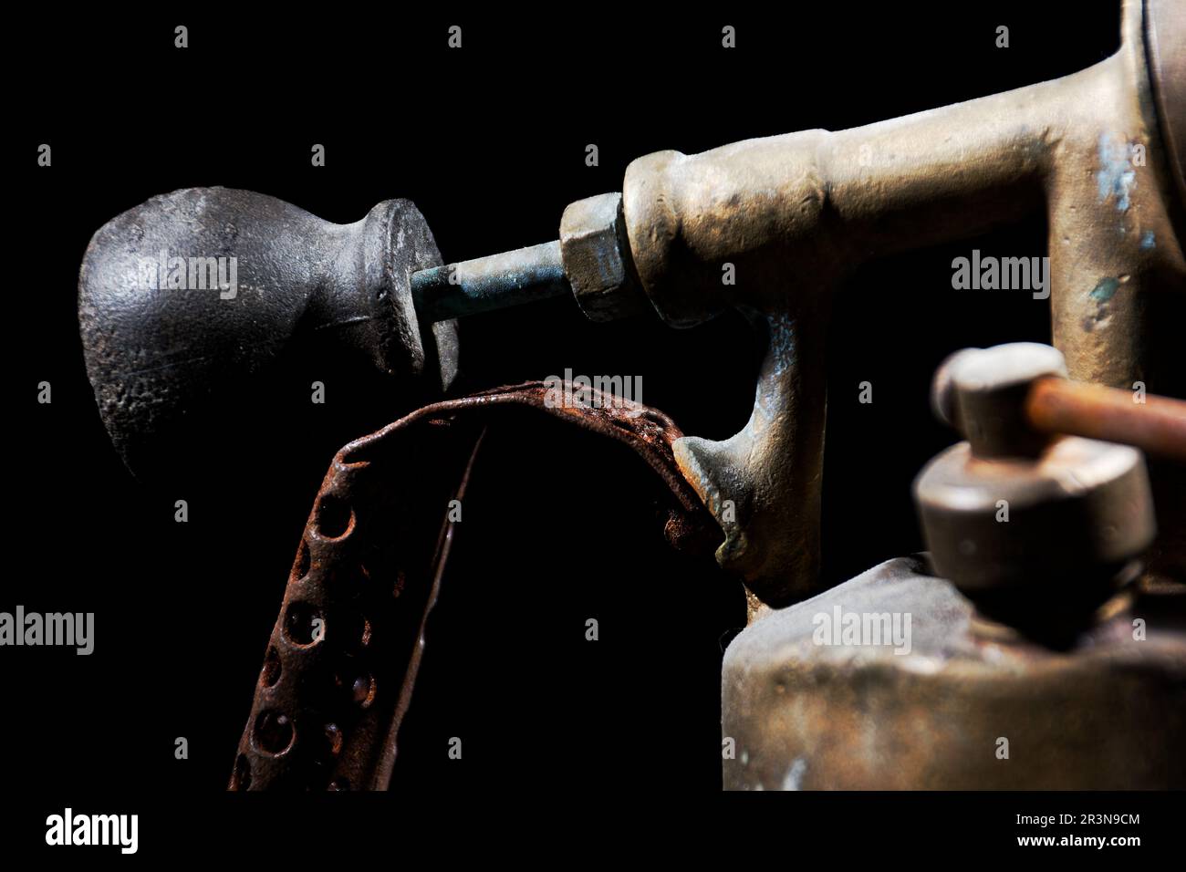 old and vintage blow torch isolated on black background with rust and ...