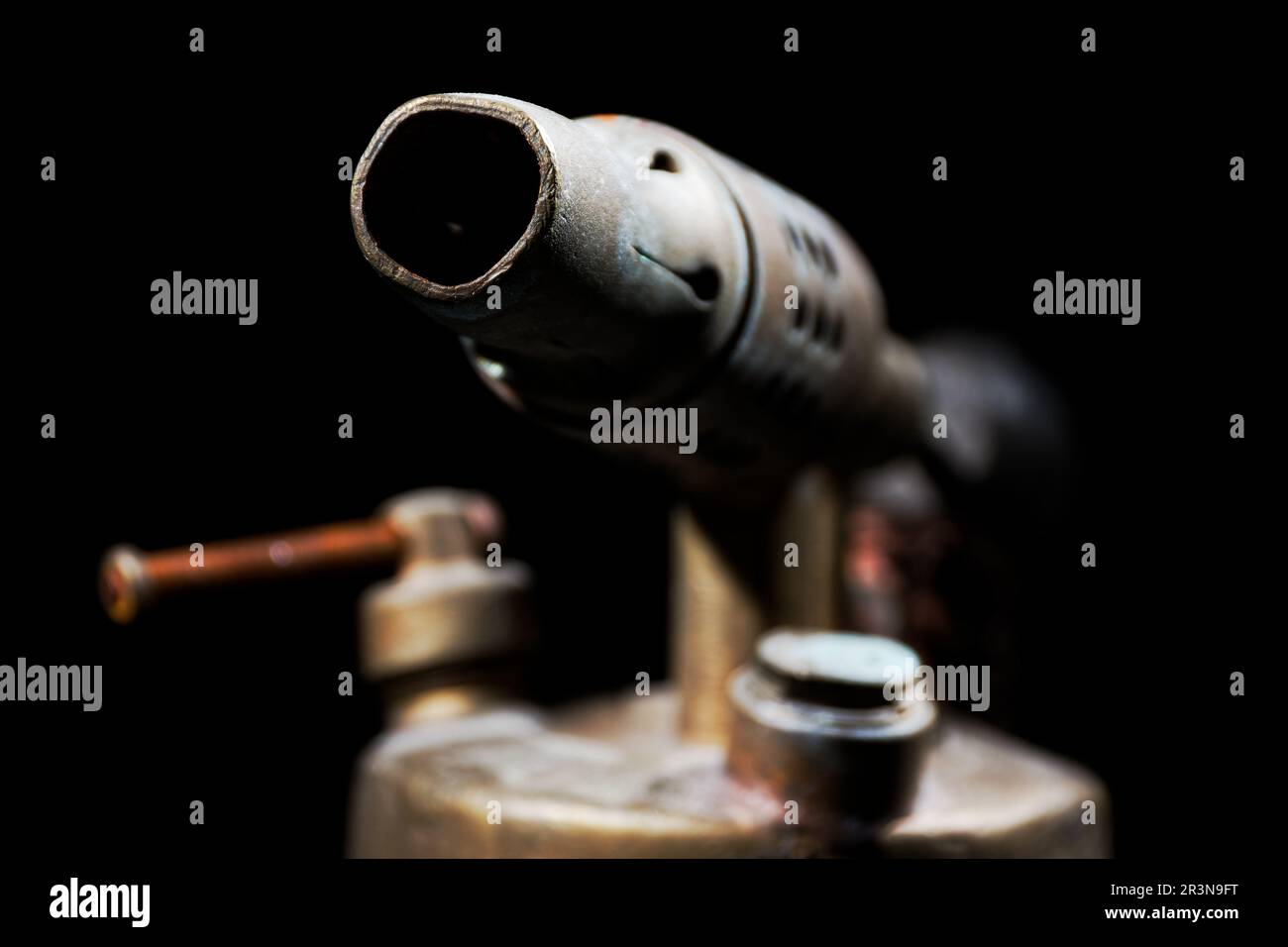 old and vintage blow torch isolated on black background with rust and ...