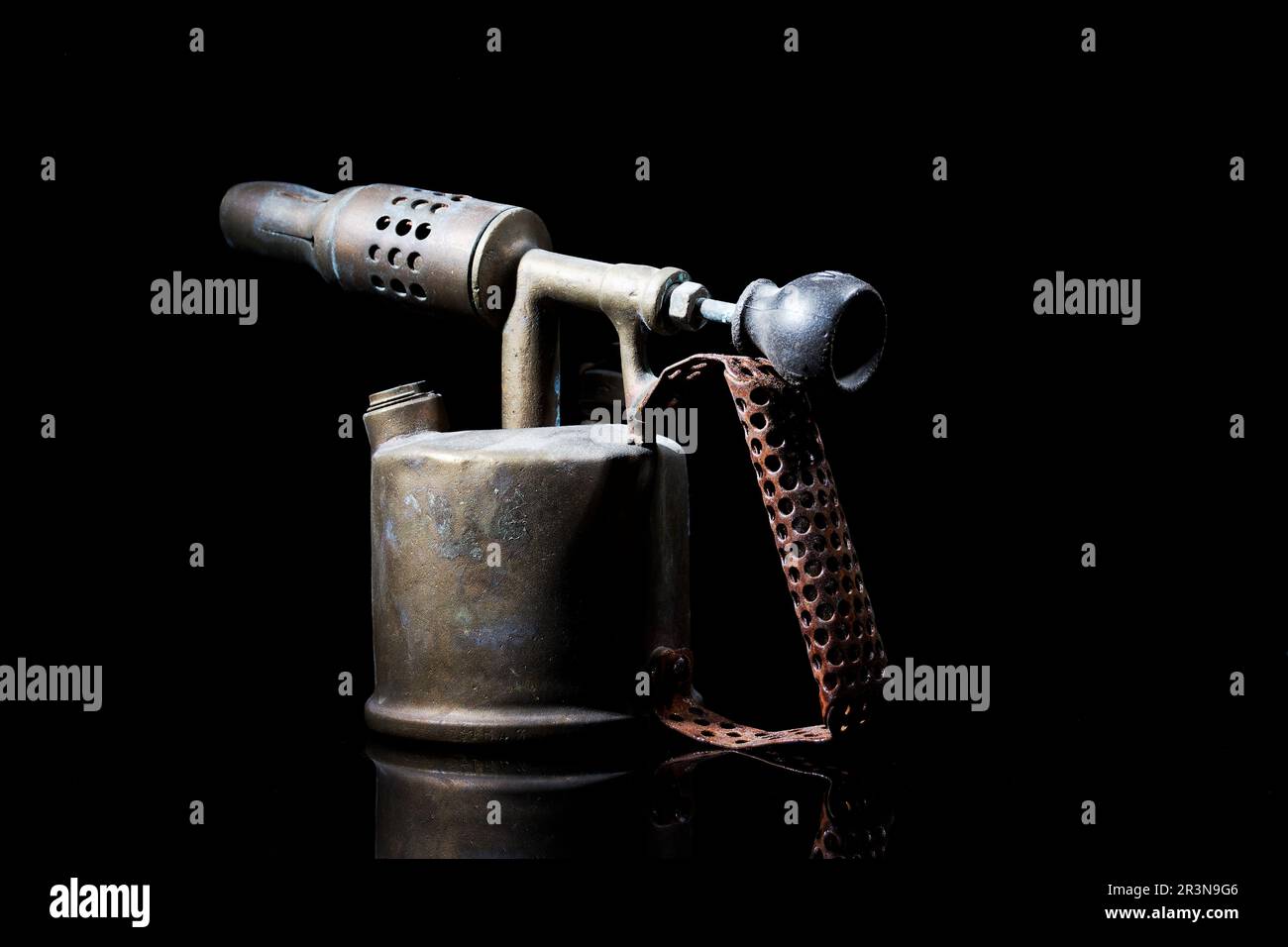 old and vintage blow torch isolated on black background with rust and ...