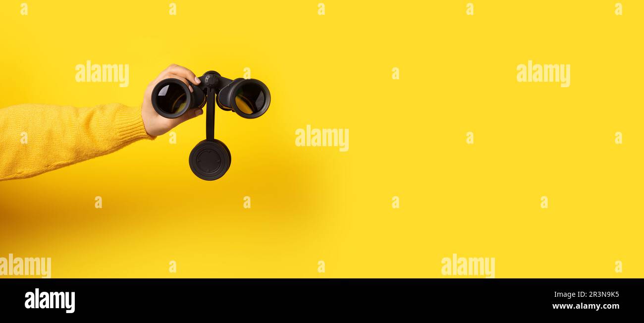 Binoculars in hand panoramic Stock Photo - Alamy