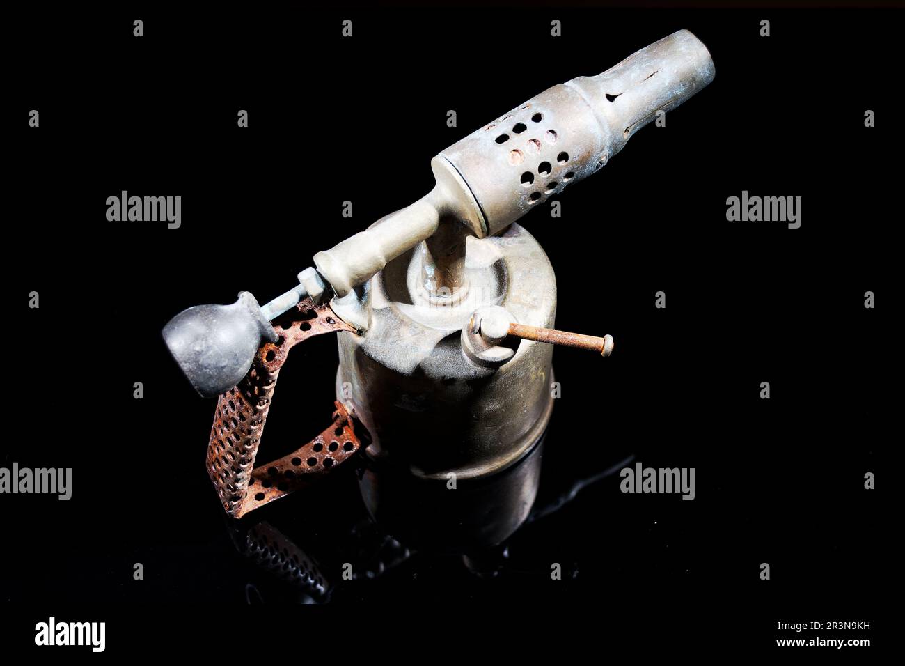 old and vintage blow torch isolated on black background with rust and ...