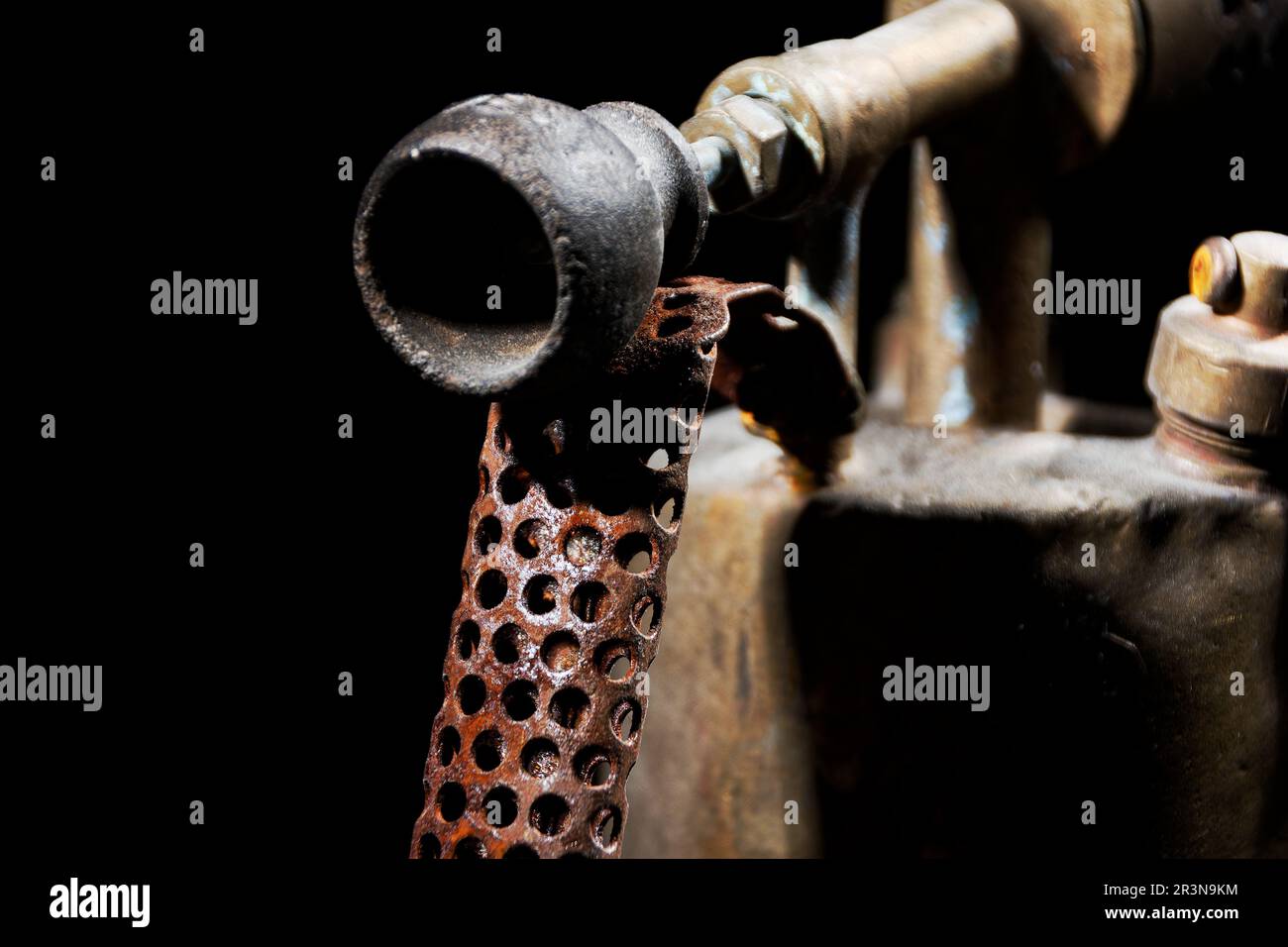 old and vintage blow torch isolated on black background with rust and ...