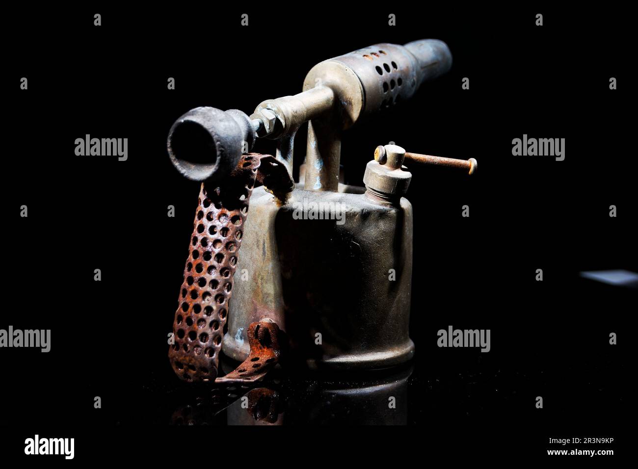 old and vintage blow torch isolated on black background with rust and ...