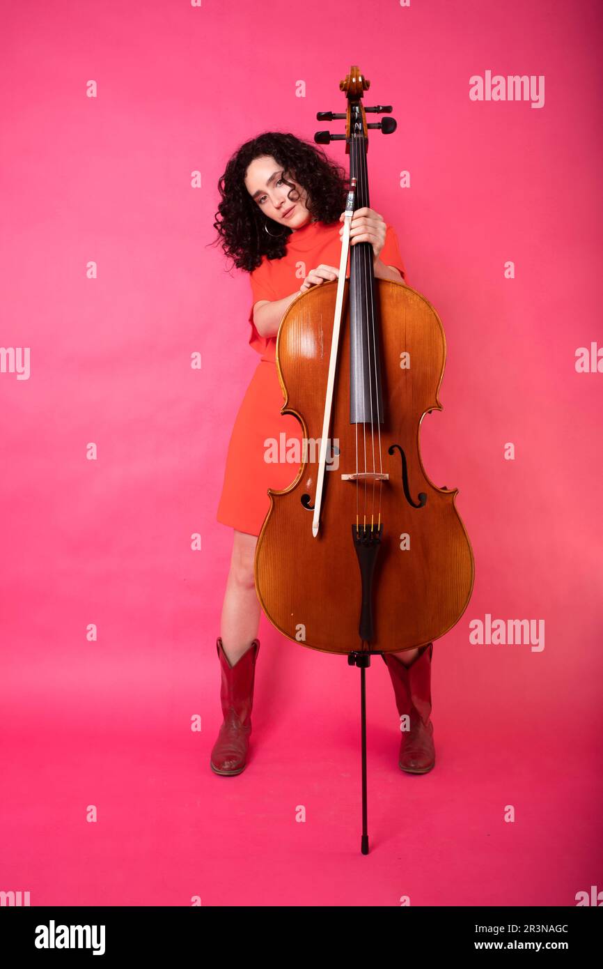 Full body of focused young female musician with curly hair wearing ...