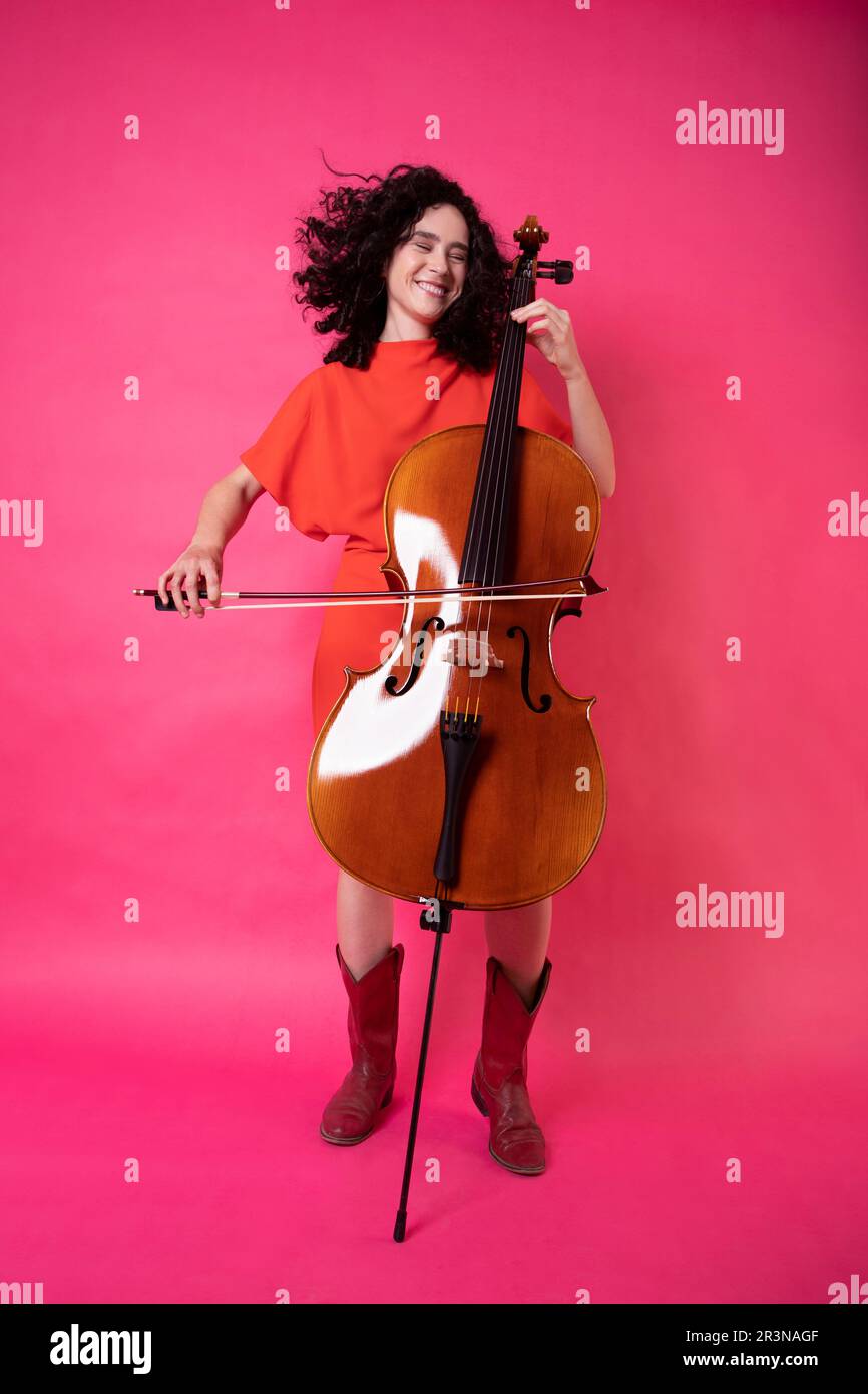 Full body of excited young female musician with curly hair wearing ...