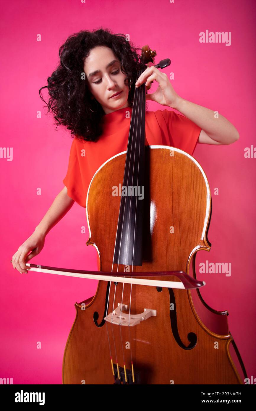 Full body of focused young female musician with curly hair wearing ...