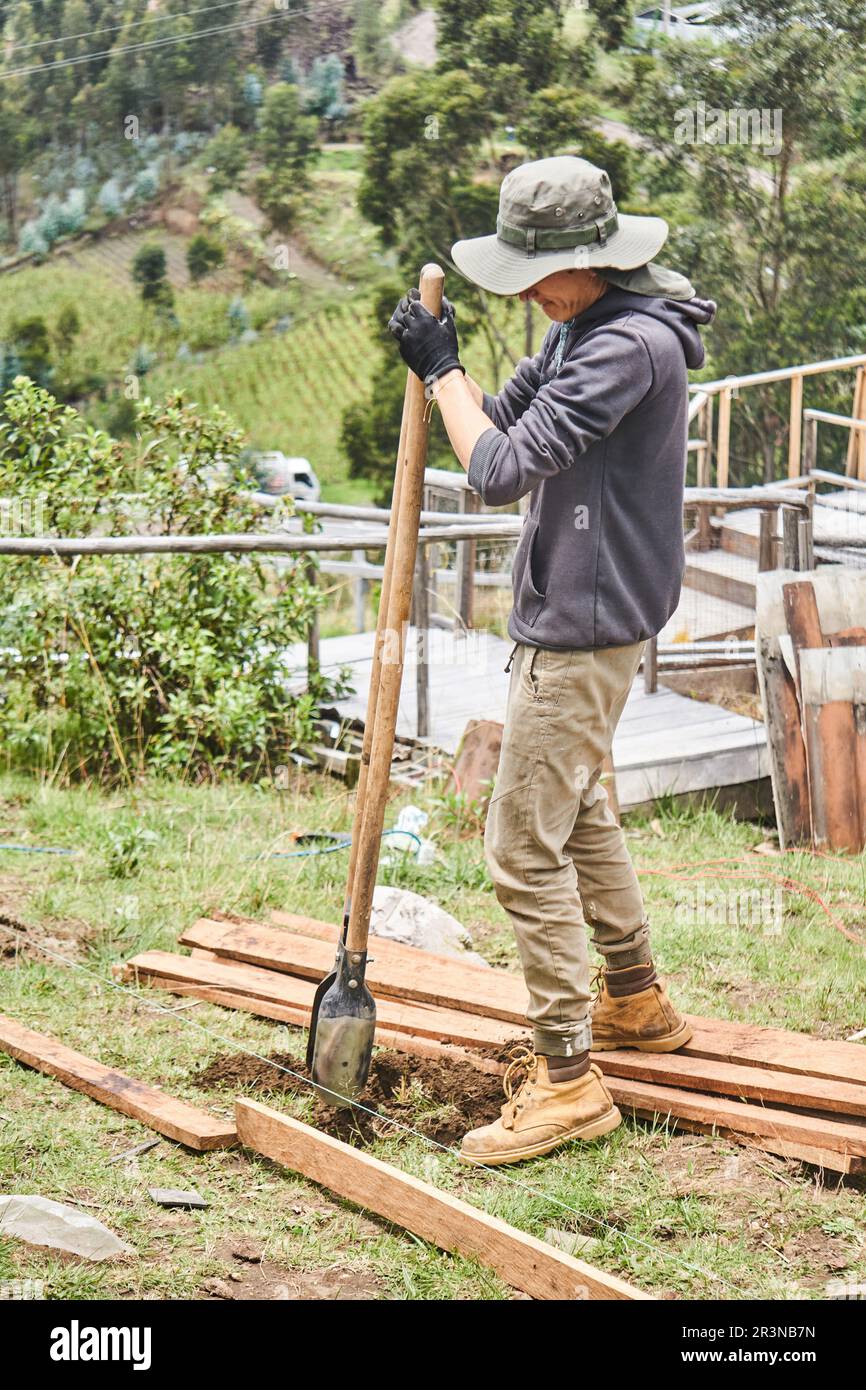 Side view of concentrated young ethnic male gardener in casual clothes ...