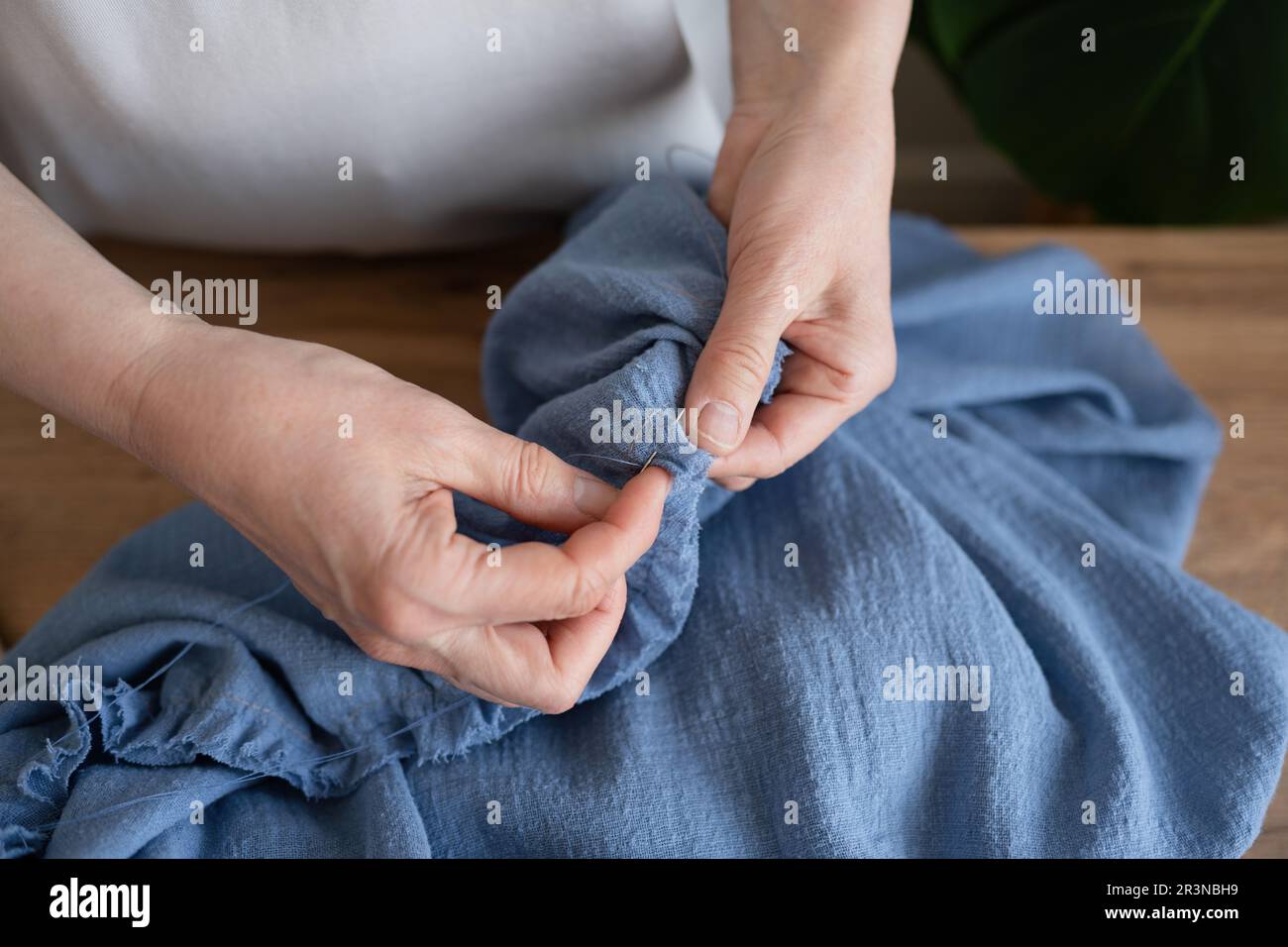 Unrecognizable cropped female tailor sewing pattern with needle and ...